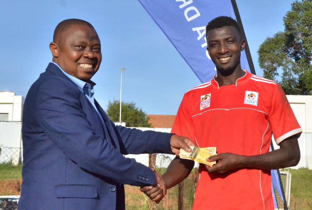 FUFA 1st VP Justus Mugisha hands over the MOTM cash to Kigezi’s Derrick ...